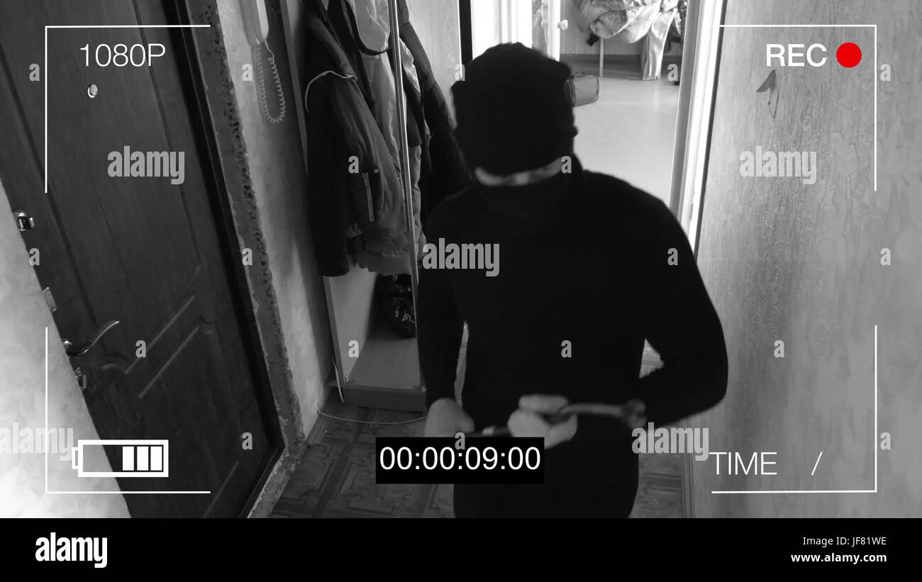 surveillance camera caught the robber in a mask with a crowbar Stock ...