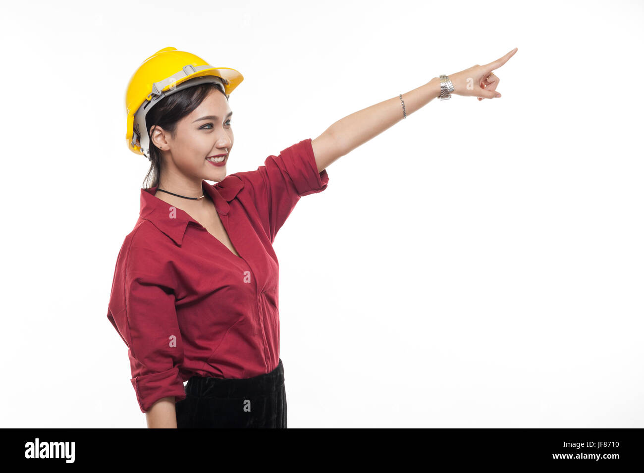 Asian woman engineer in red shirt and yellow safety cap pointing front ...