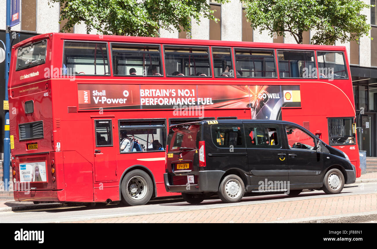 Red National Express Midlands bus and a black taxi (motion blur) in ...