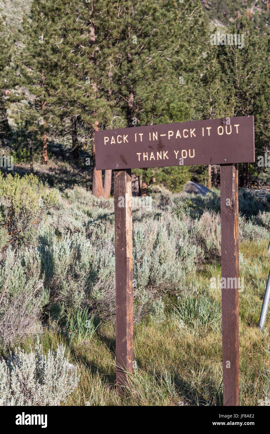 Wooden Pack it in pack it out trail sign reminding hikers walkers and ...