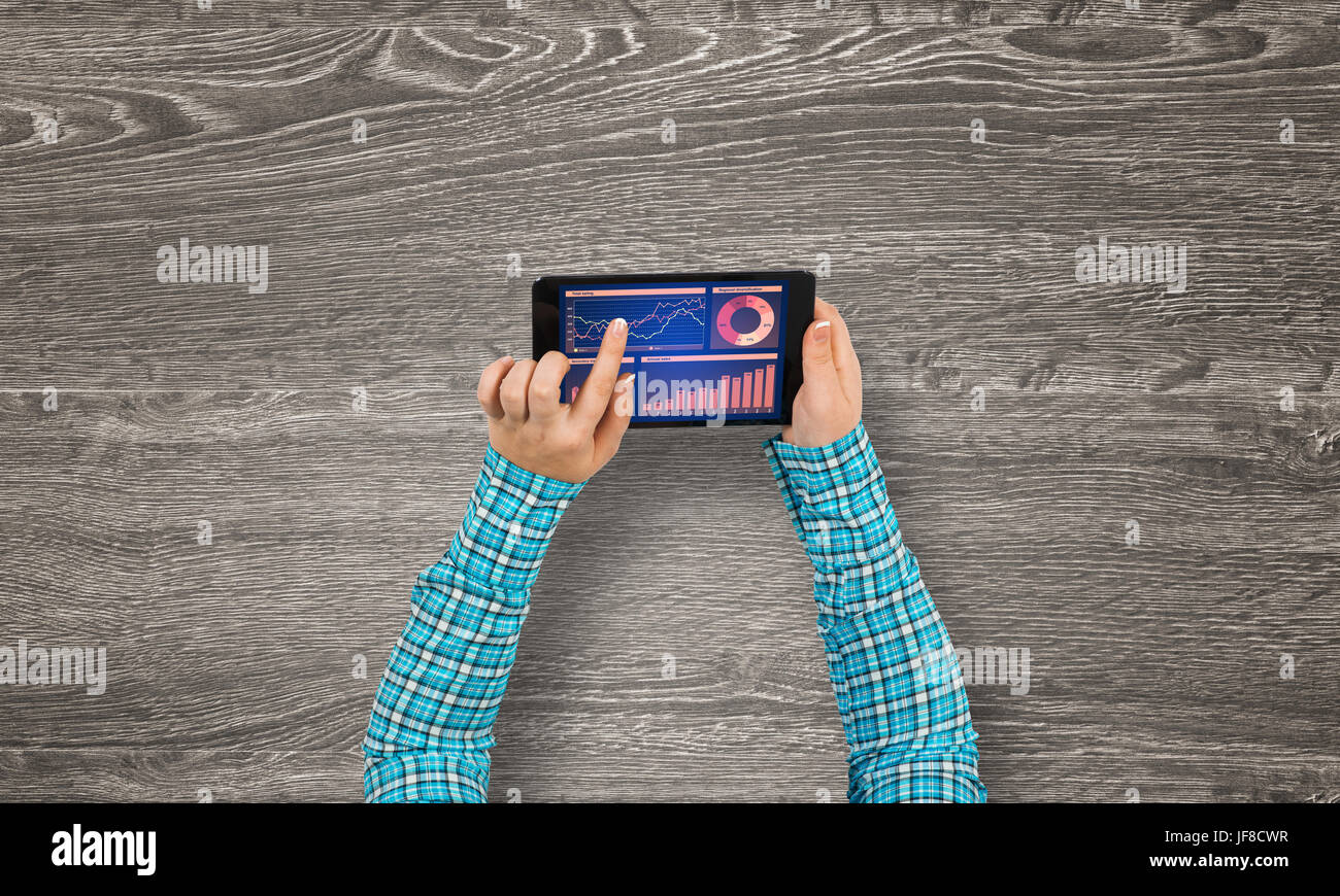 Top view of girl hands using tablet pc with diagrams and graphs on ...
