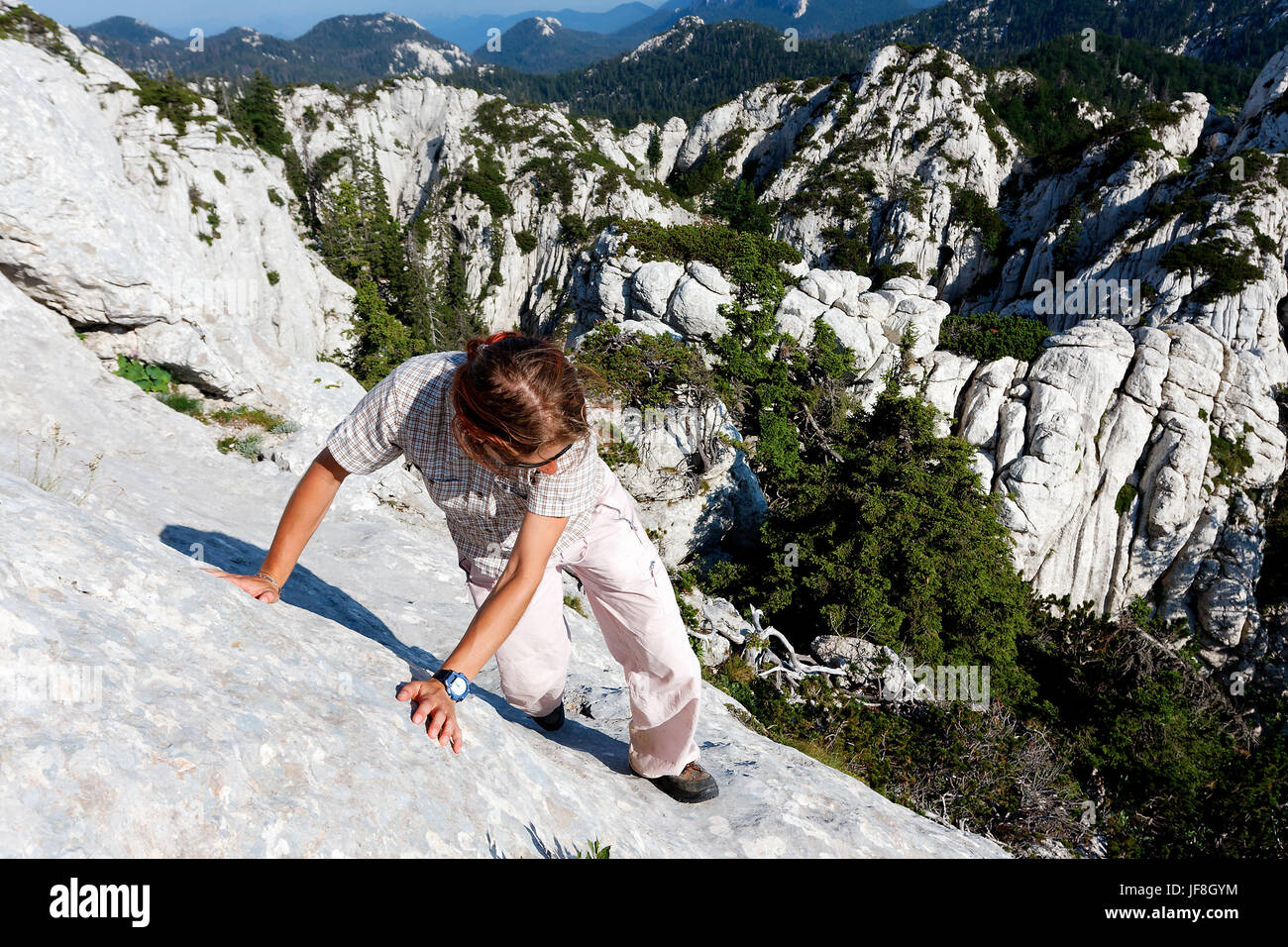 Woman is climbing on the rocks in Velebit mountain, Croatia Stock Photo ...