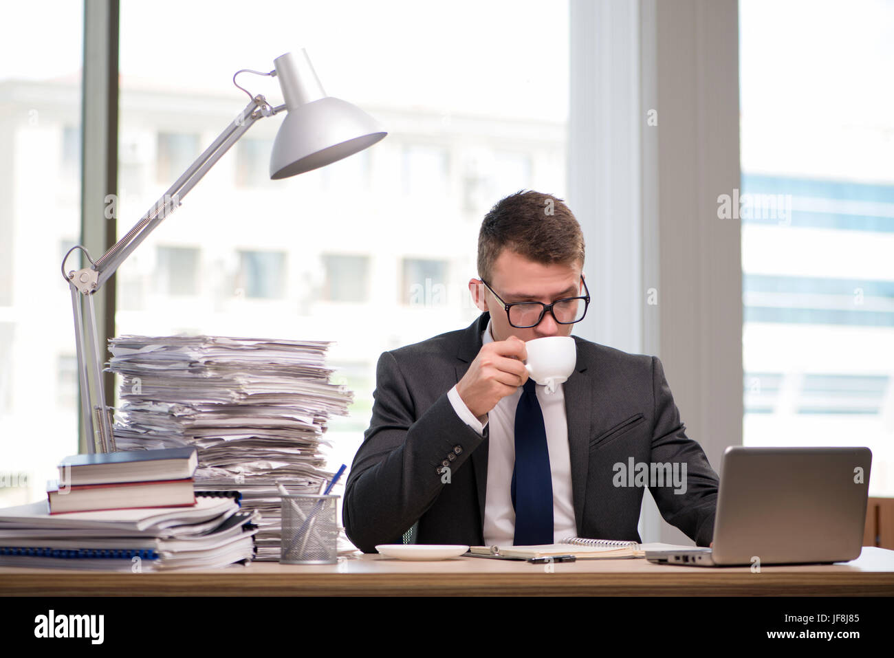 Young businessman drinking tea in the office Stock Photo - Alamy