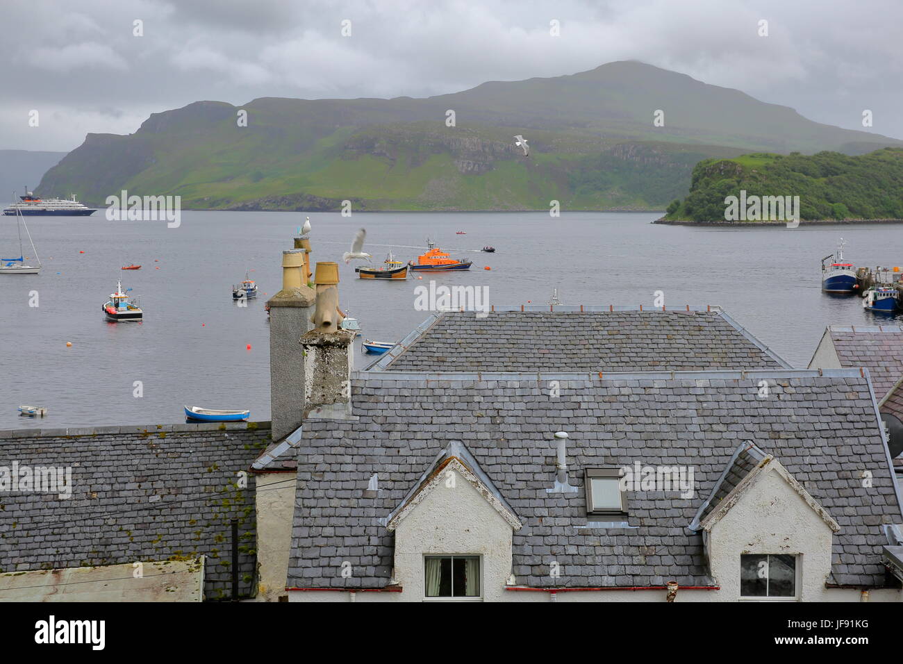 View of Portree Bay from Portree Harbor with traditional slate roofs in ...