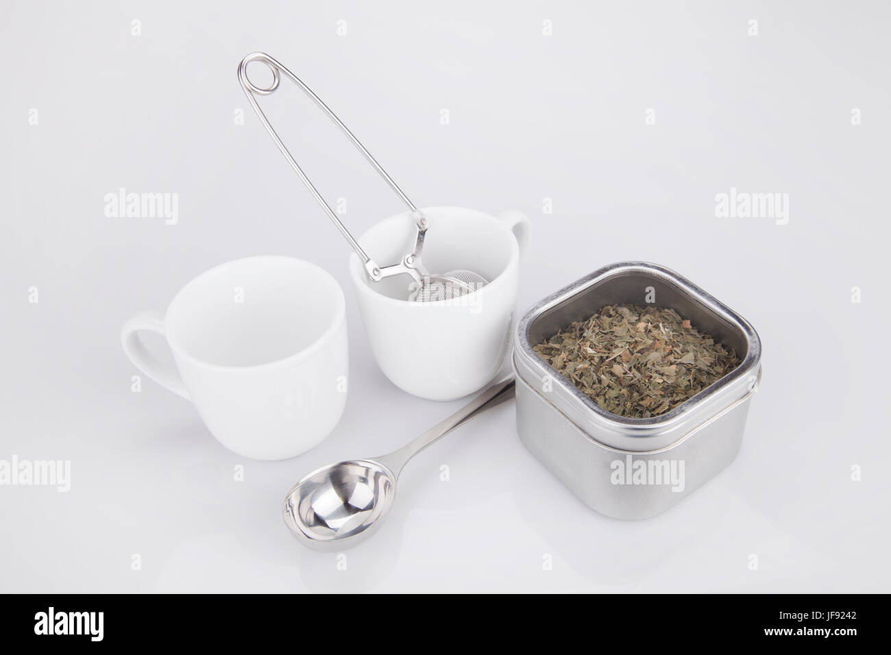 Tea leaves and accessories on a white surface. Tea kit isolated on ...