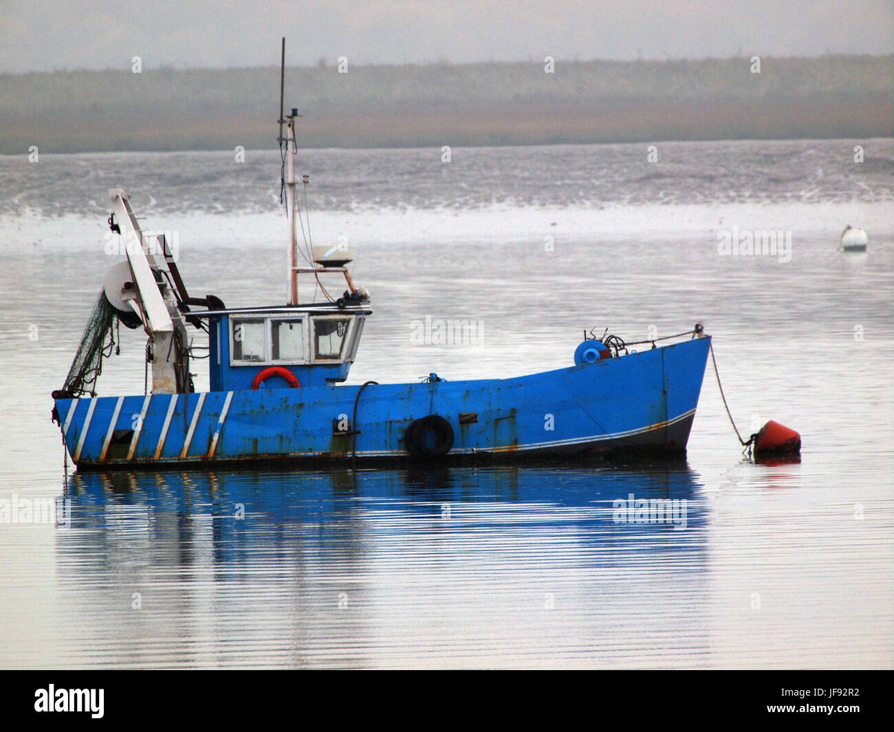 A blue fishing boat / trawler moored near Harty Ferry on the Swale in ...