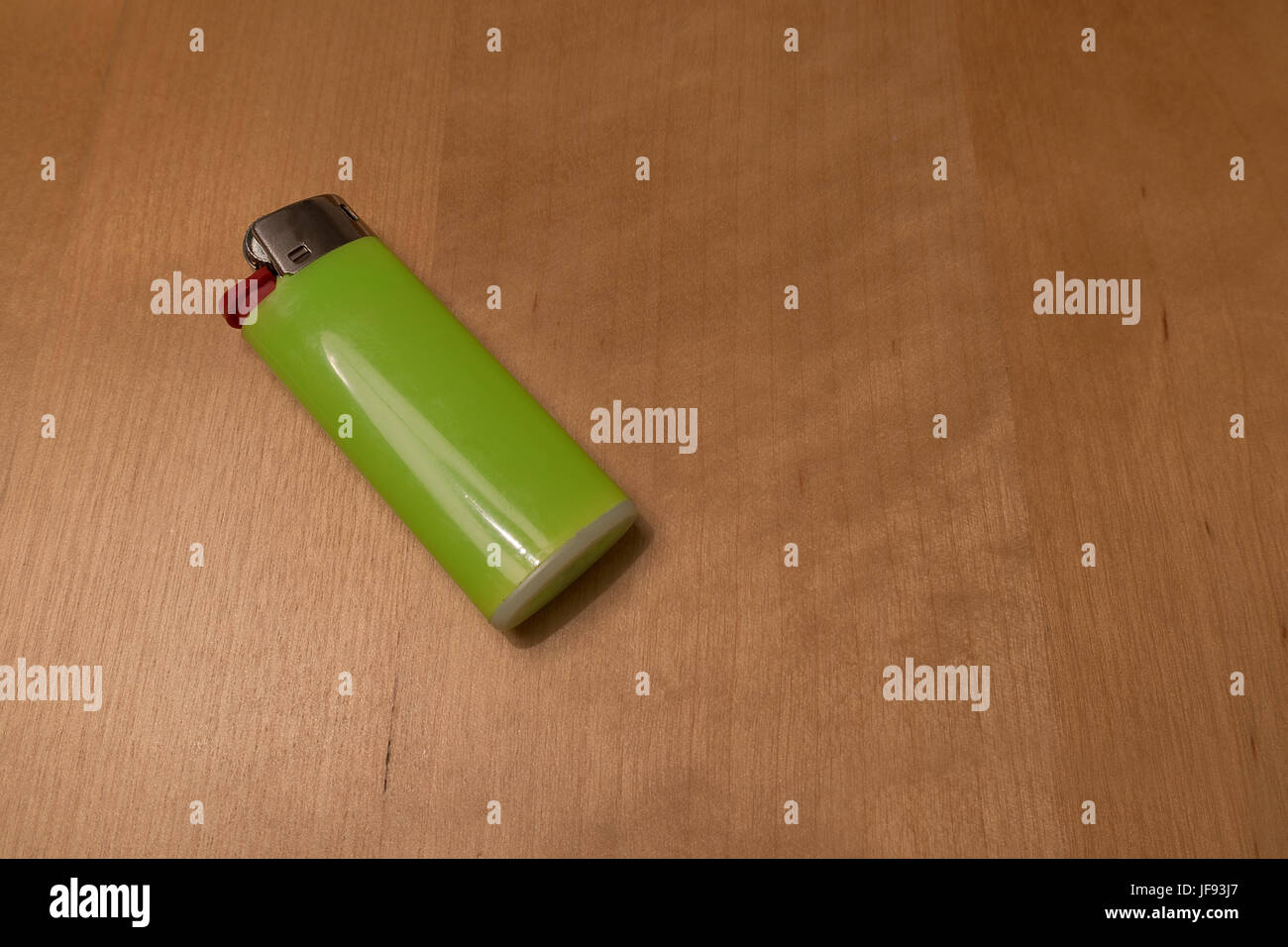 Isolated green lighter with wooden background Stock Photo - Alamy