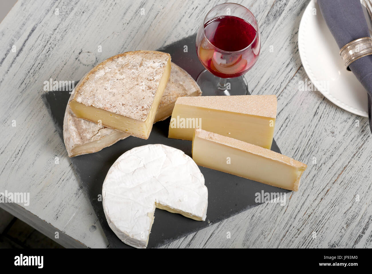 Different french cheeses with a glass of red wine Stock Photo - Alamy