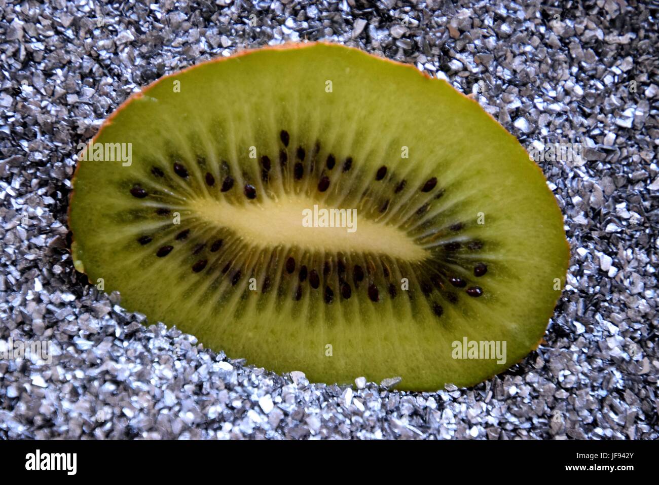 cut chinese gooseberry abstract look in front of silver background ...