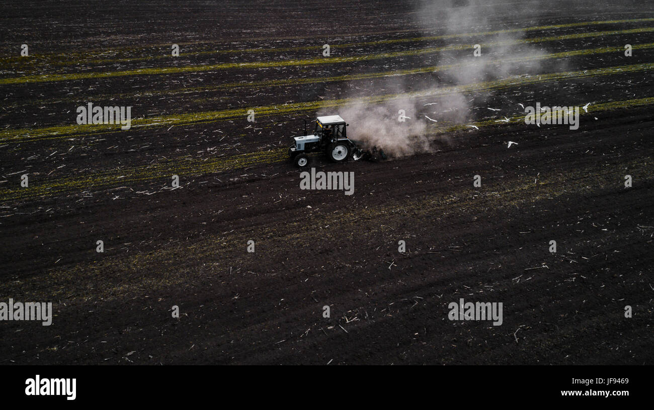 Tractor cultivating field at spring, aerial view Stock Photo - Alamy