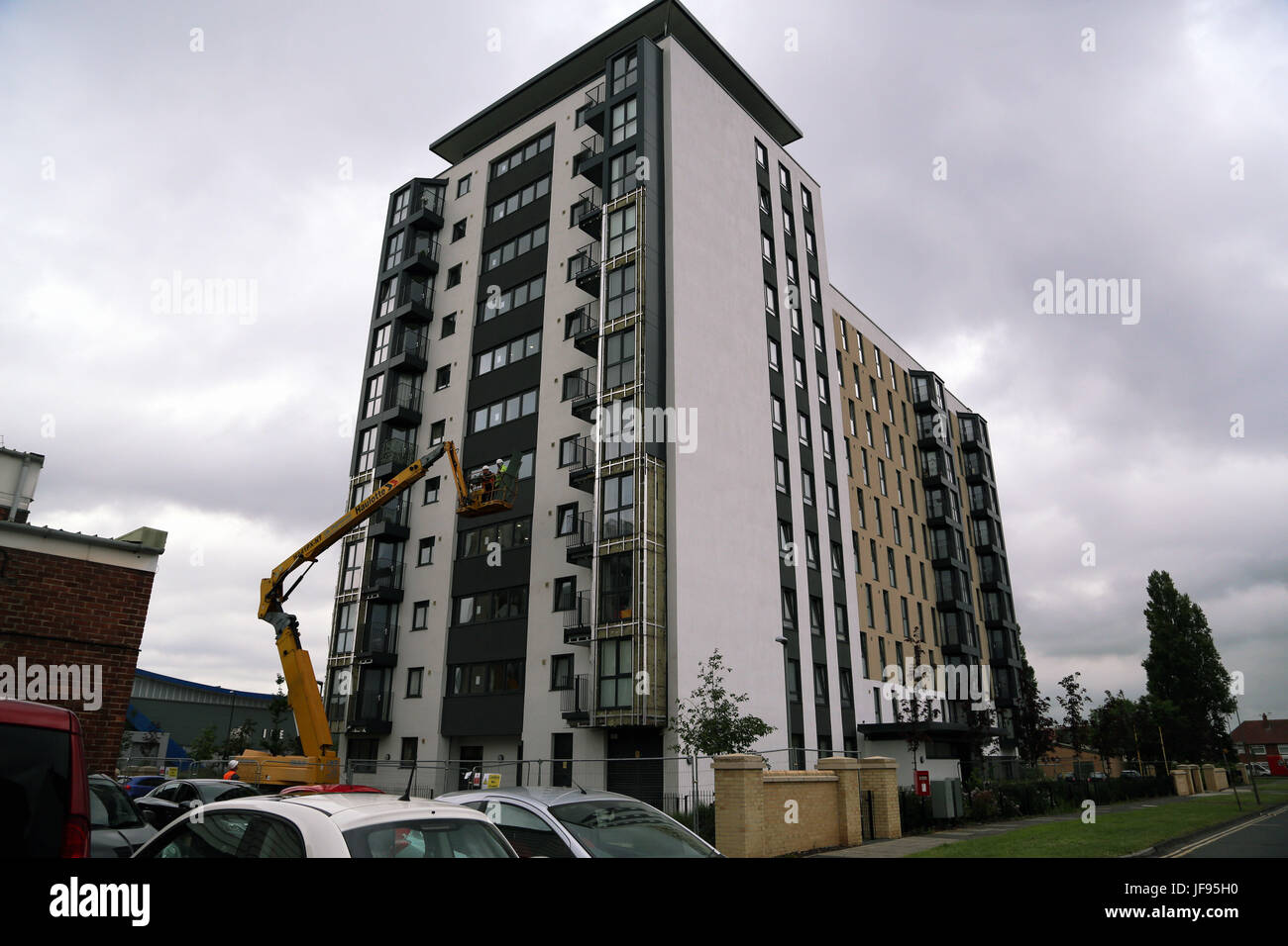 Workers on a cherry picker remove cladding panels from Kennedy Gardens ...