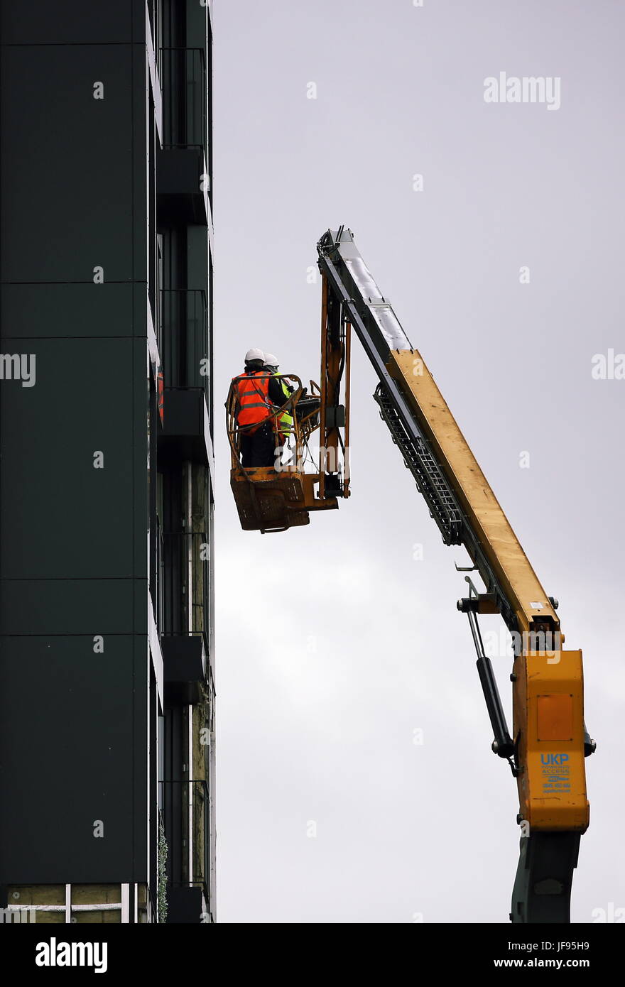 Workers on a cherry picker remove cladding panels from Kennedy Gardens ...