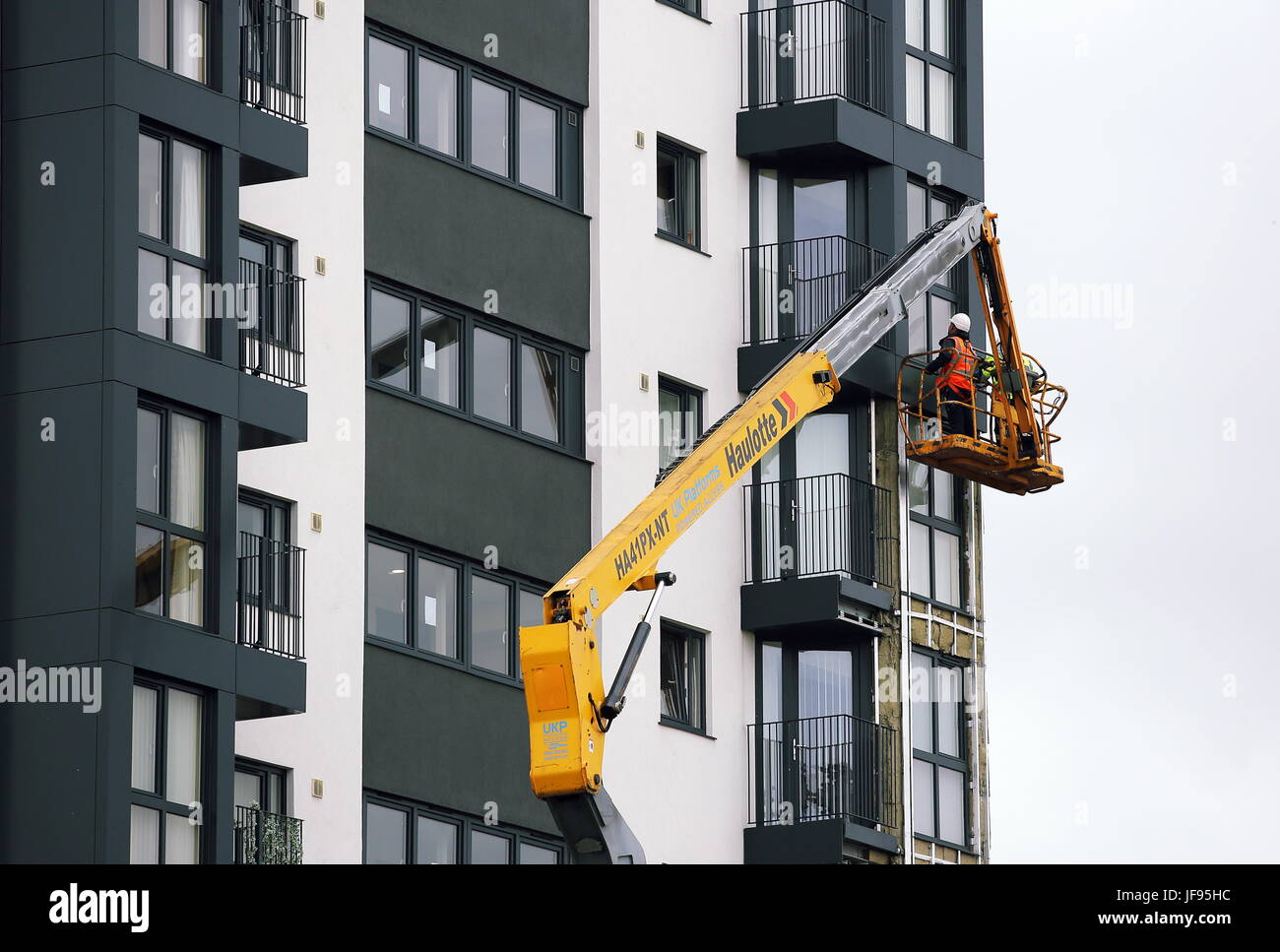 Workers on a cherry picker remove cladding panels from Kennedy Gardens ...