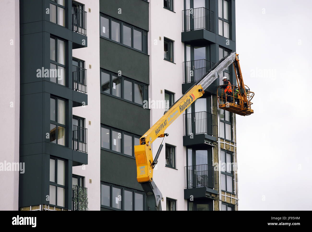 Workers on a cherry picker remove cladding panels from Kennedy Gardens ...