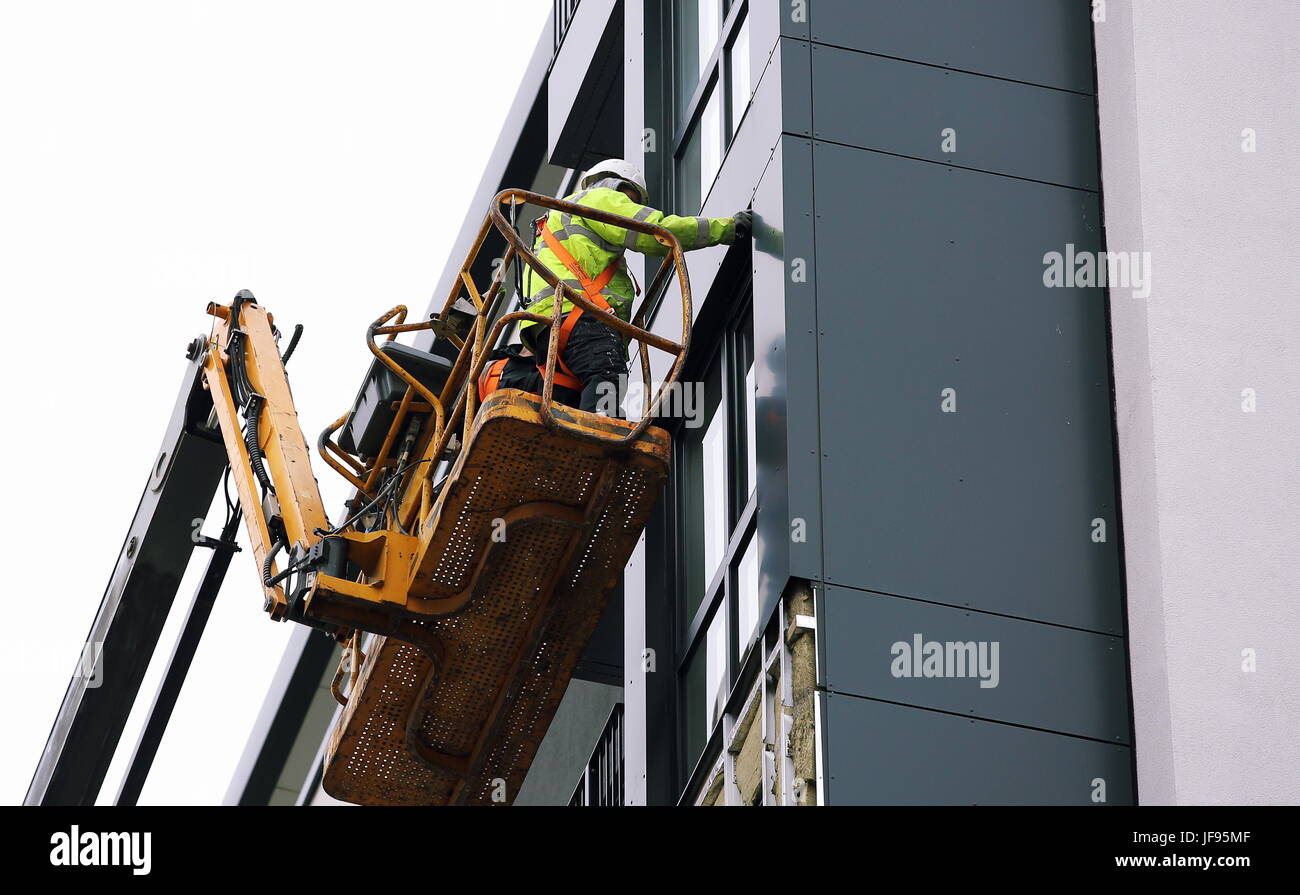 Workers on a cherry picker remove cladding panels from Kennedy Gardens ...