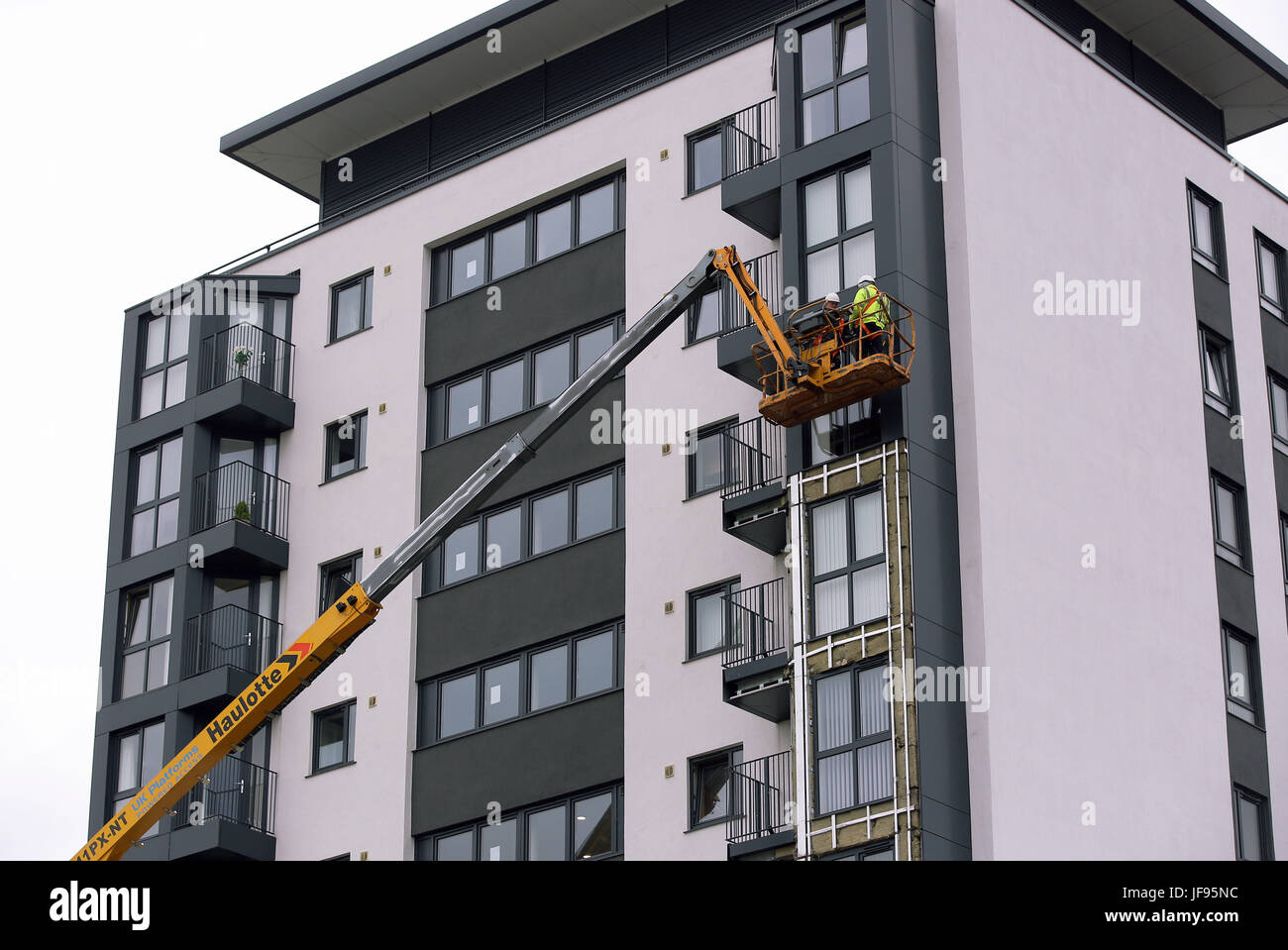 Workers on a cherry picker remove cladding panels from Kennedy Gardens ...