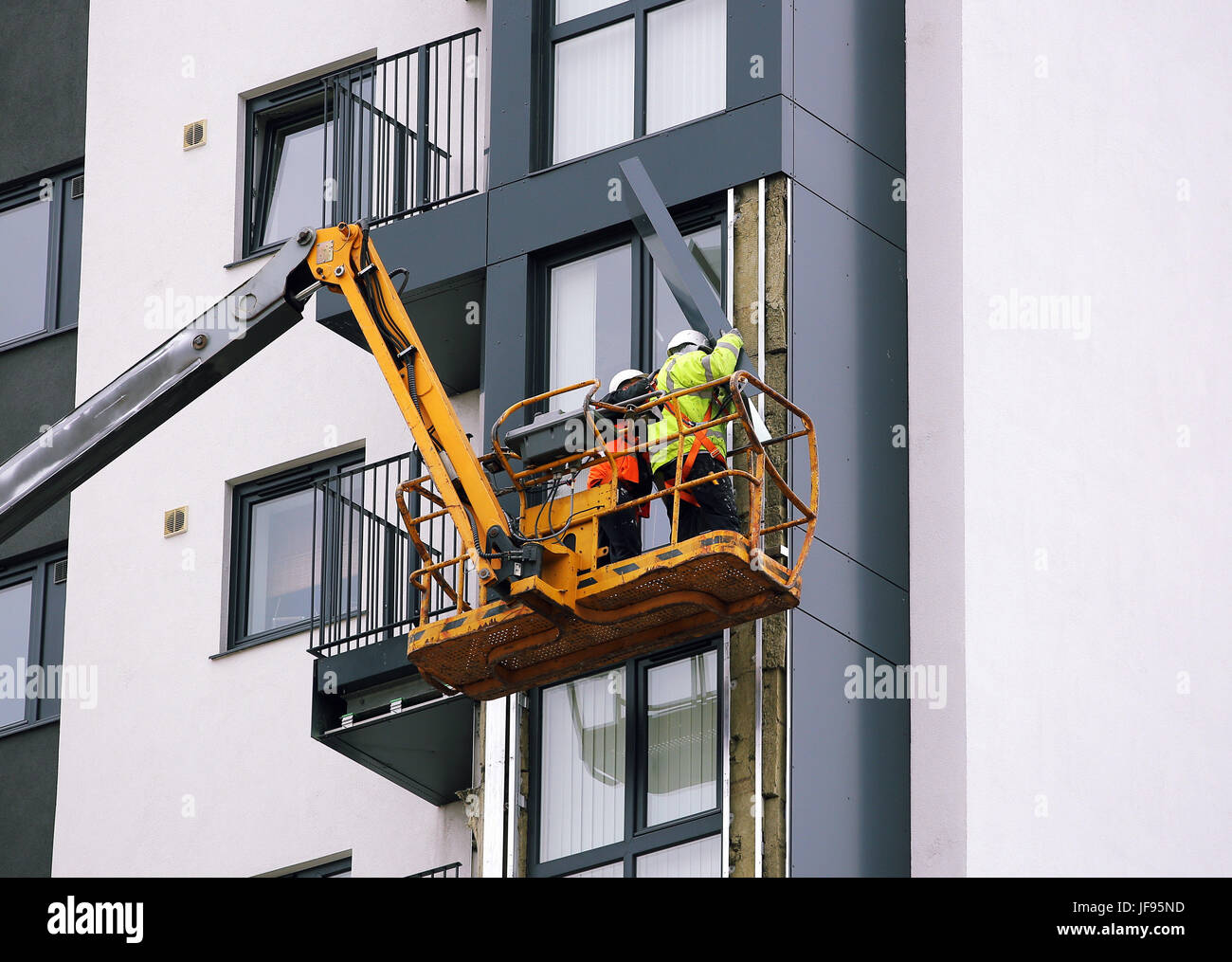 Workers on a cherry picker remove cladding panels from Kennedy Gardens ...