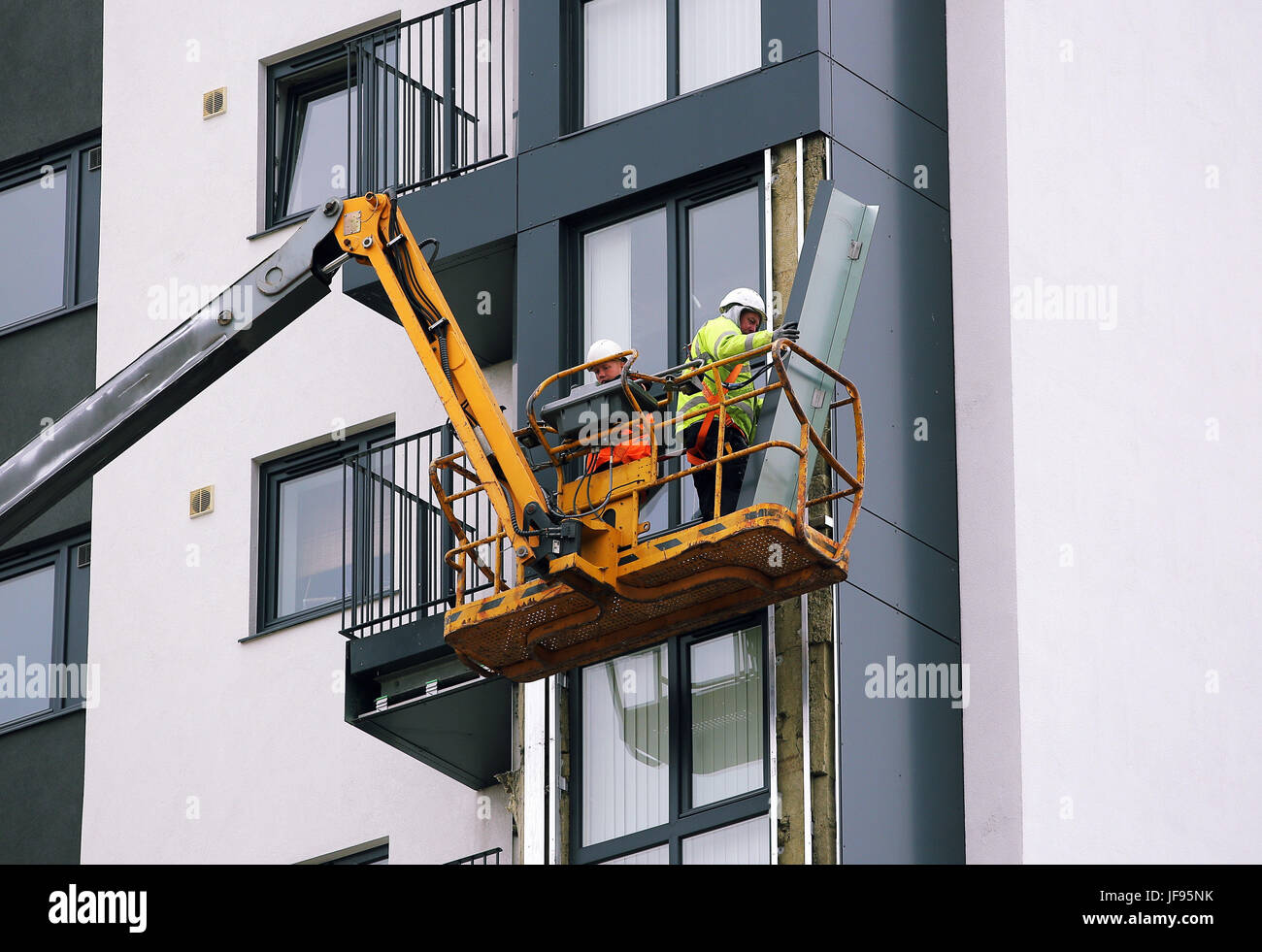 Workers on a cherry picker remove cladding panels from Kennedy Gardens ...