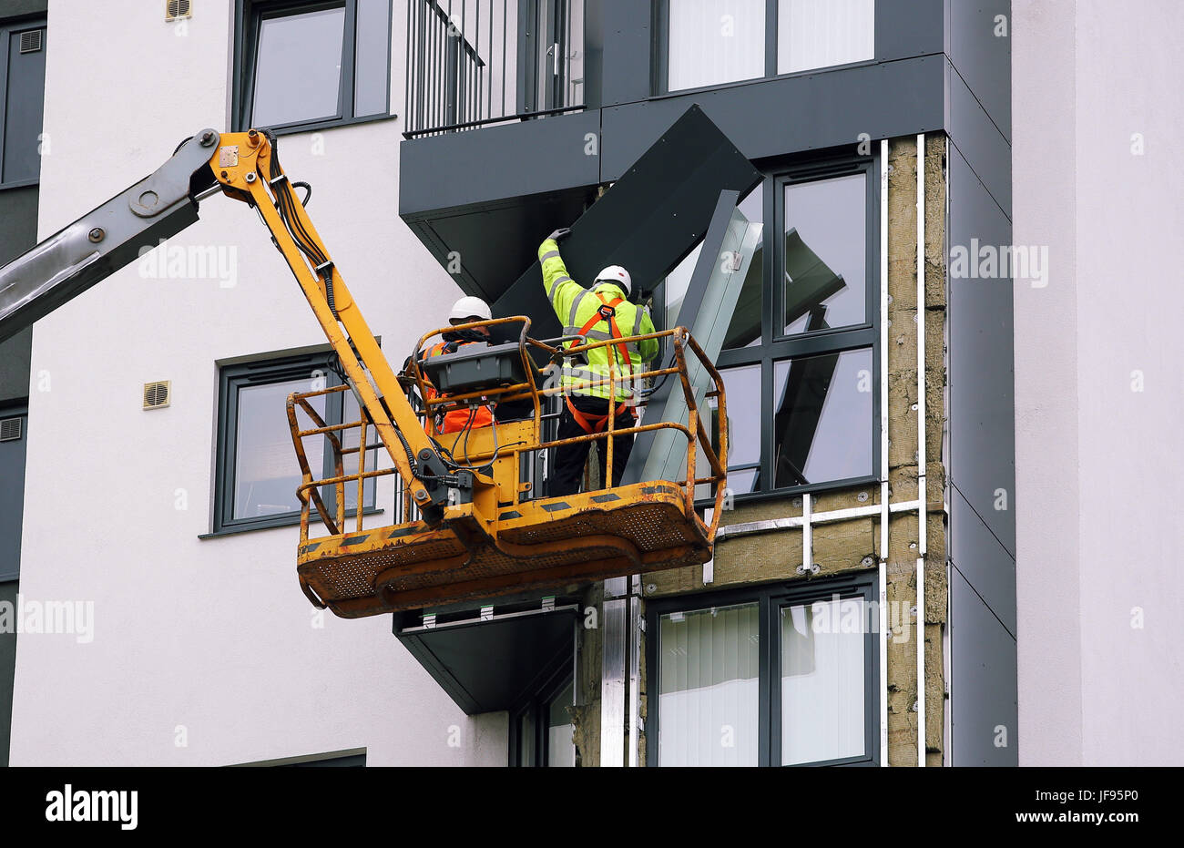 Workers on a cherry picker remove cladding panels from Kennedy Gardens ...