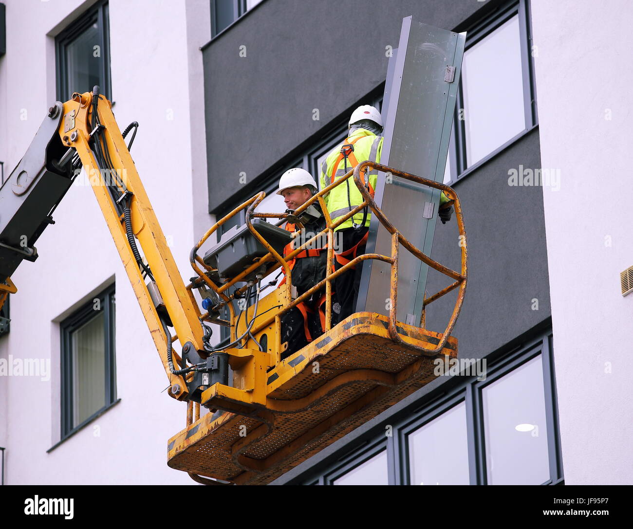 Workers on a cherry picker remove cladding panels from Kennedy Gardens ...