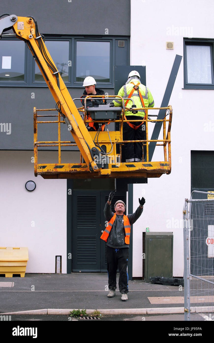 Workers on a cherry picker remove cladding panels from Kennedy Gardens ...