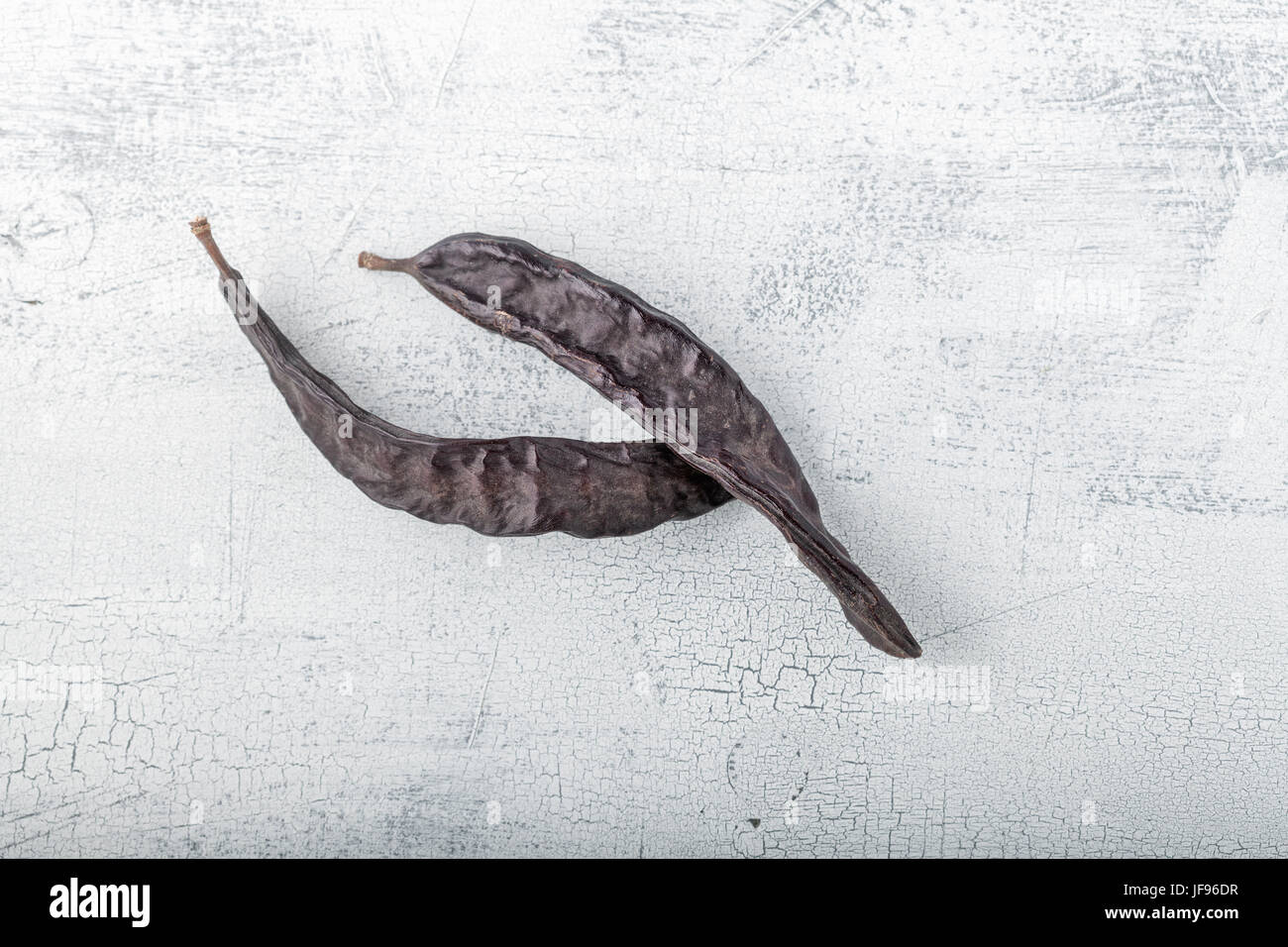 Two Big Carobs on a wooden background Stock Photo - Alamy