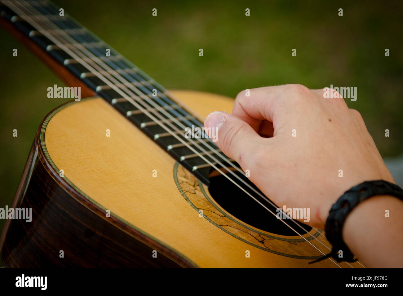 A man strums an acoustic guitar Stock Photo - Alamy
