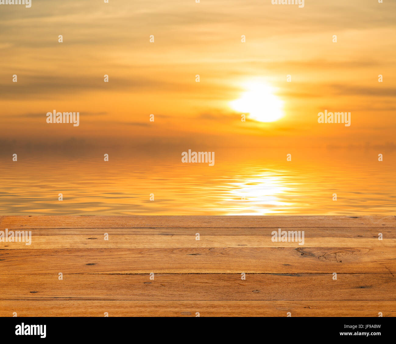 Sunset over calm off wooden deck Stock Photo - Alamy
