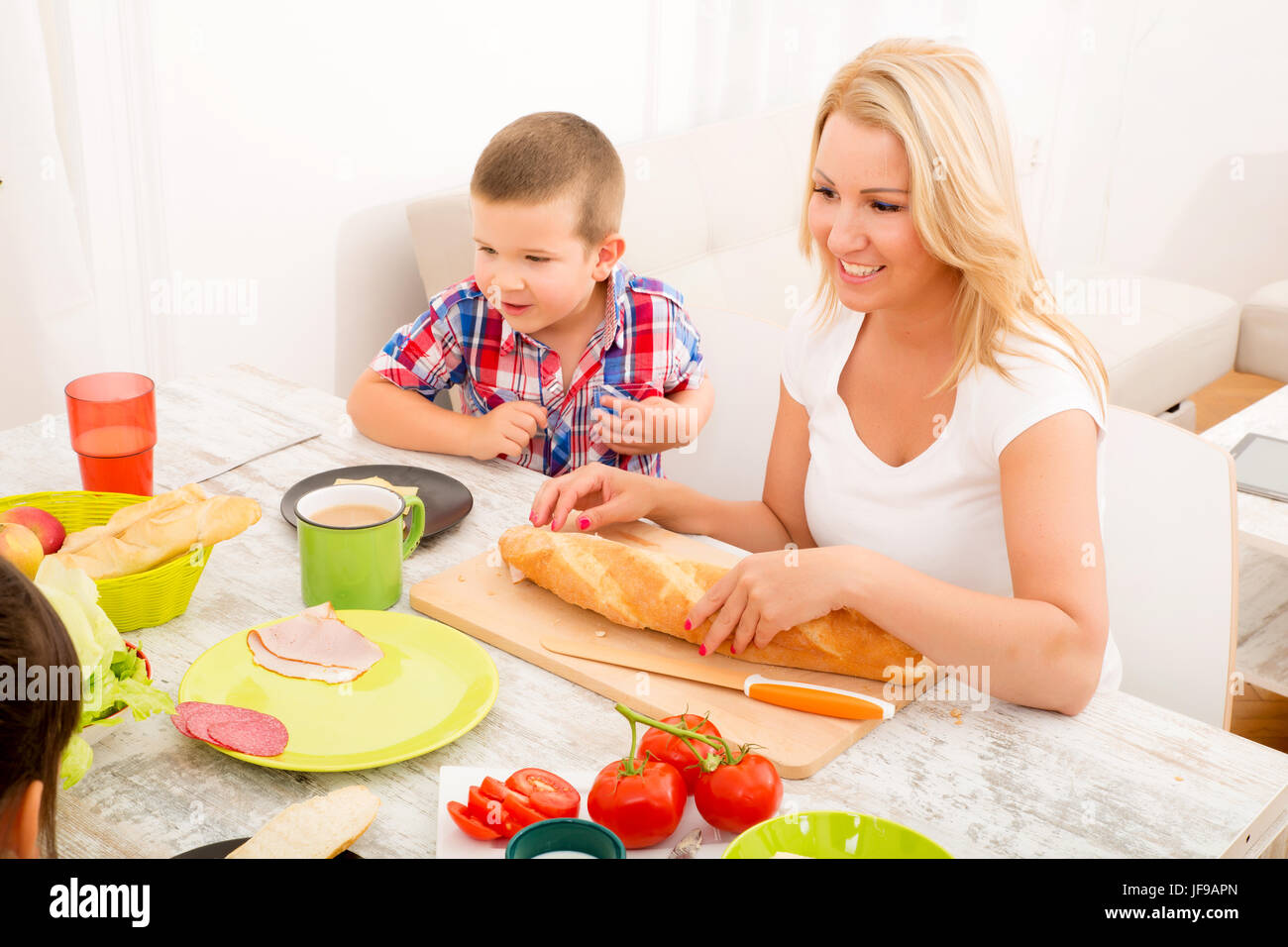 Happy family having breakfast at home Stock Photo - Alamy