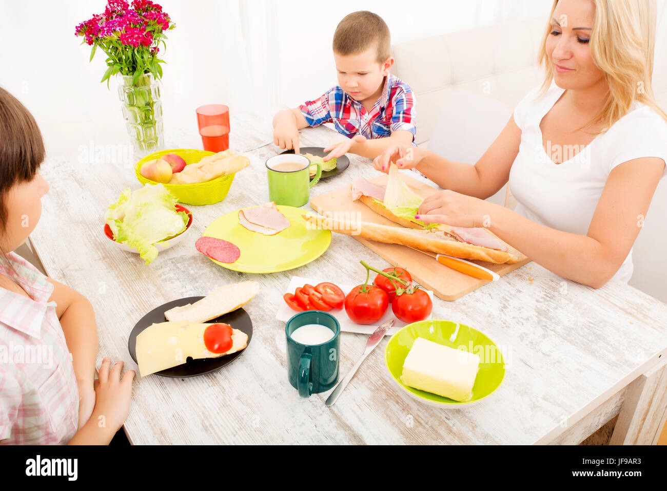 Happy family having breakfast at home Stock Photo - Alamy
