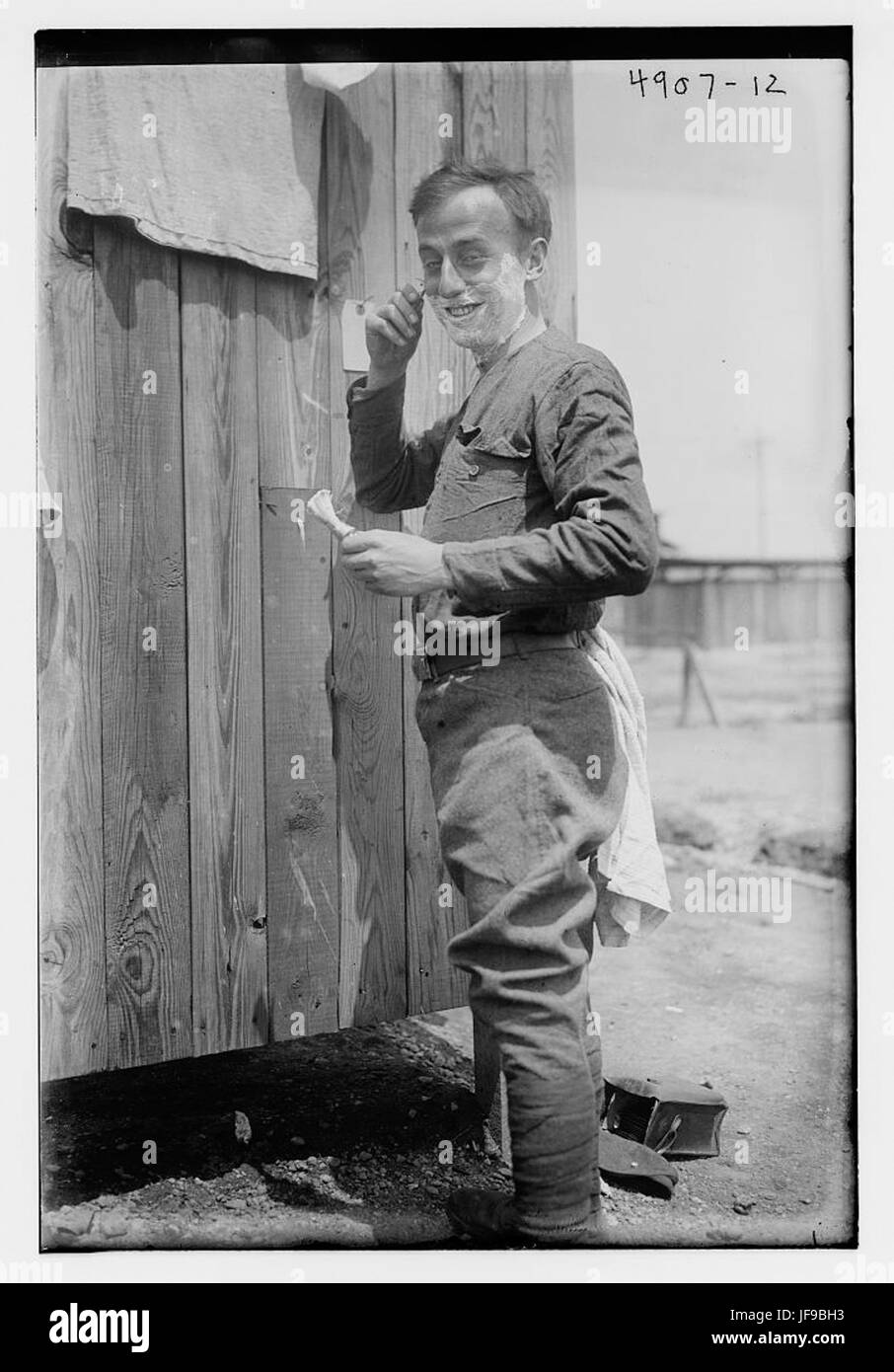 A soldier shaving during a brief moment of calm, capturing a personal ...