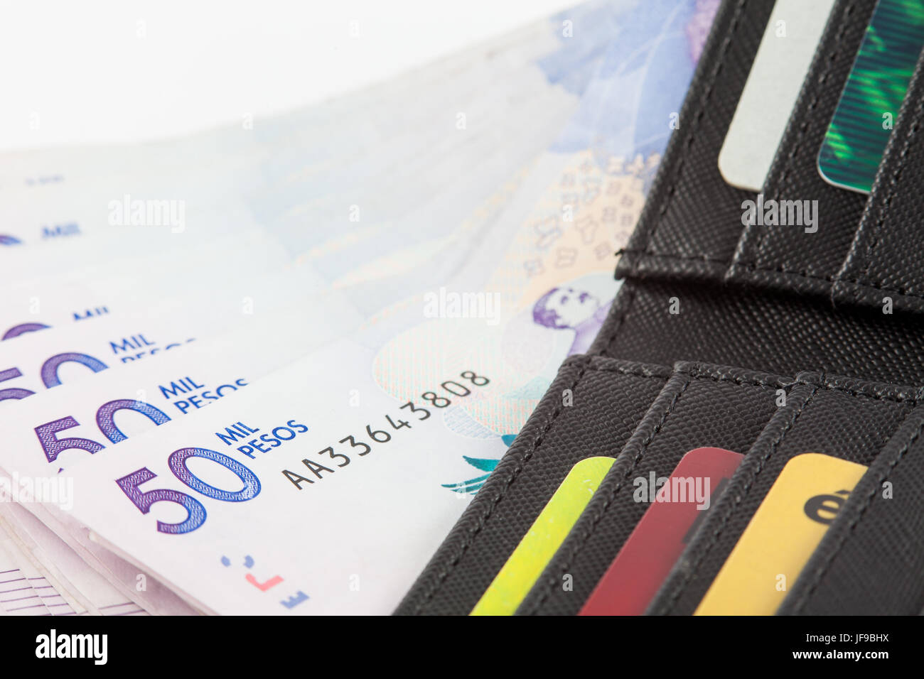 Black wallet filled with fifty thousand Colombian pesos bills Stock ...