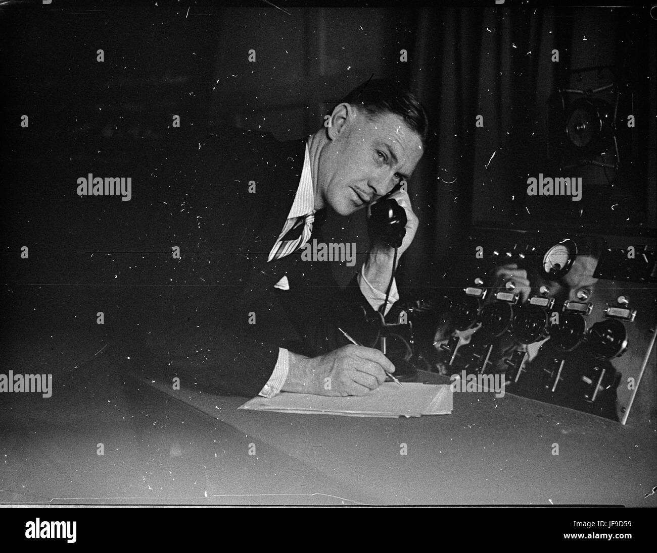 An image of a person using the telephone inside a radio studio ...
