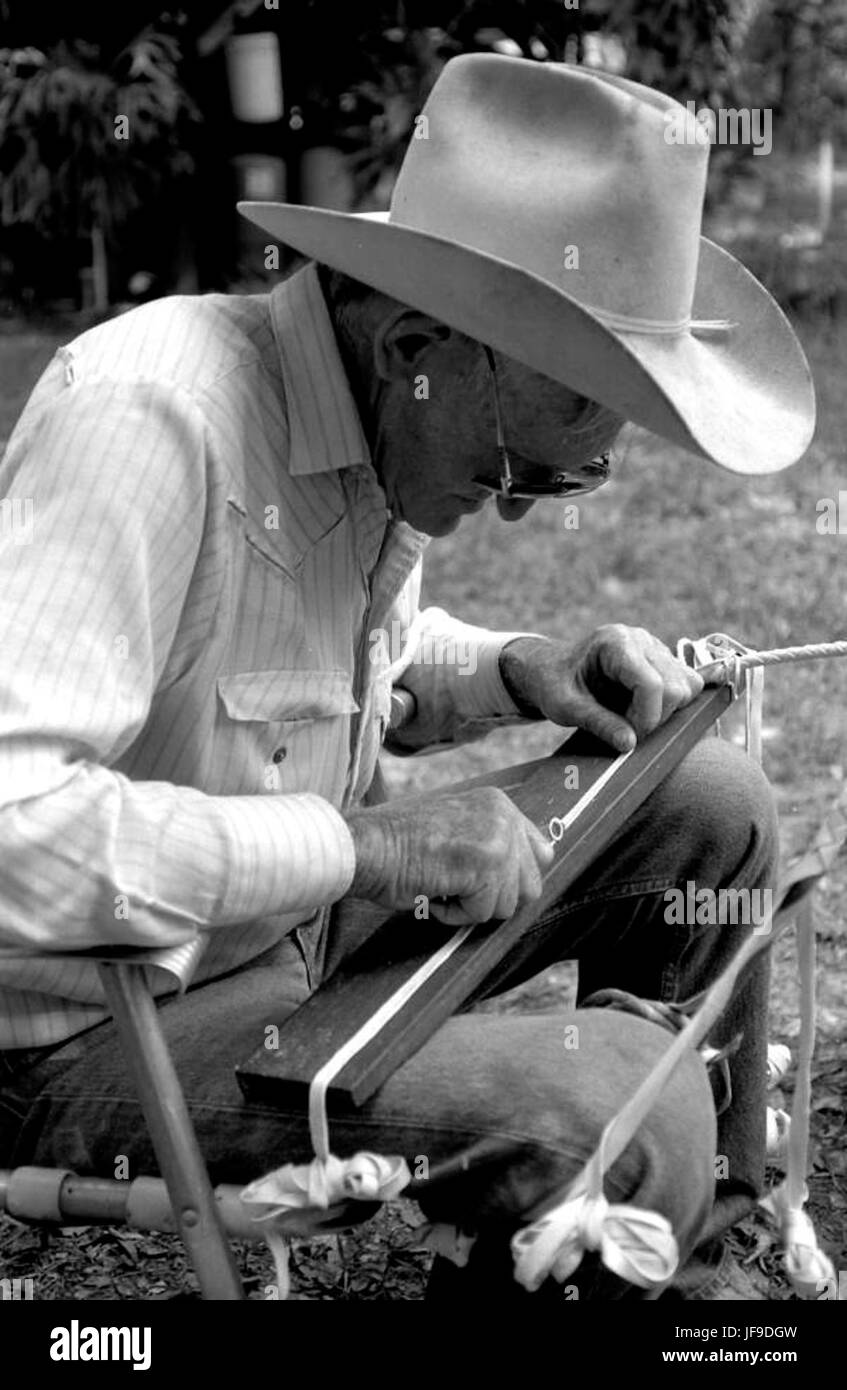 A historical photograph of George Junior Mills, a cow whip maker from ...