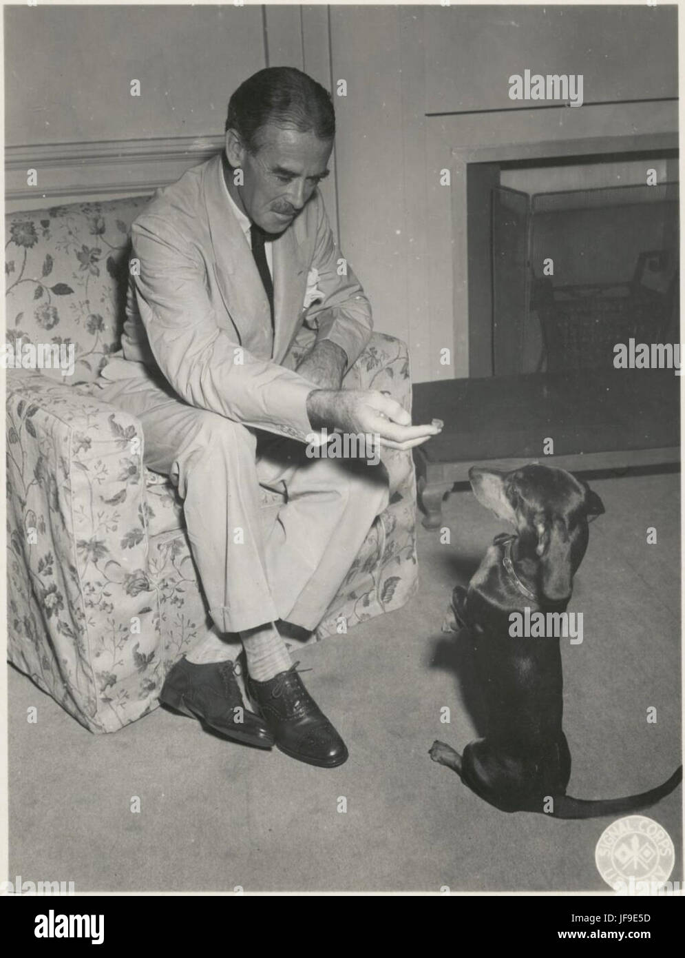 A candid photograph of RG Casey seated with his pet dog Mizr, captured ...