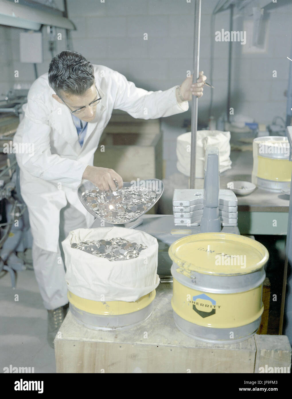 A photograph showing the process of weighing coins at Sherritt Gordon ...