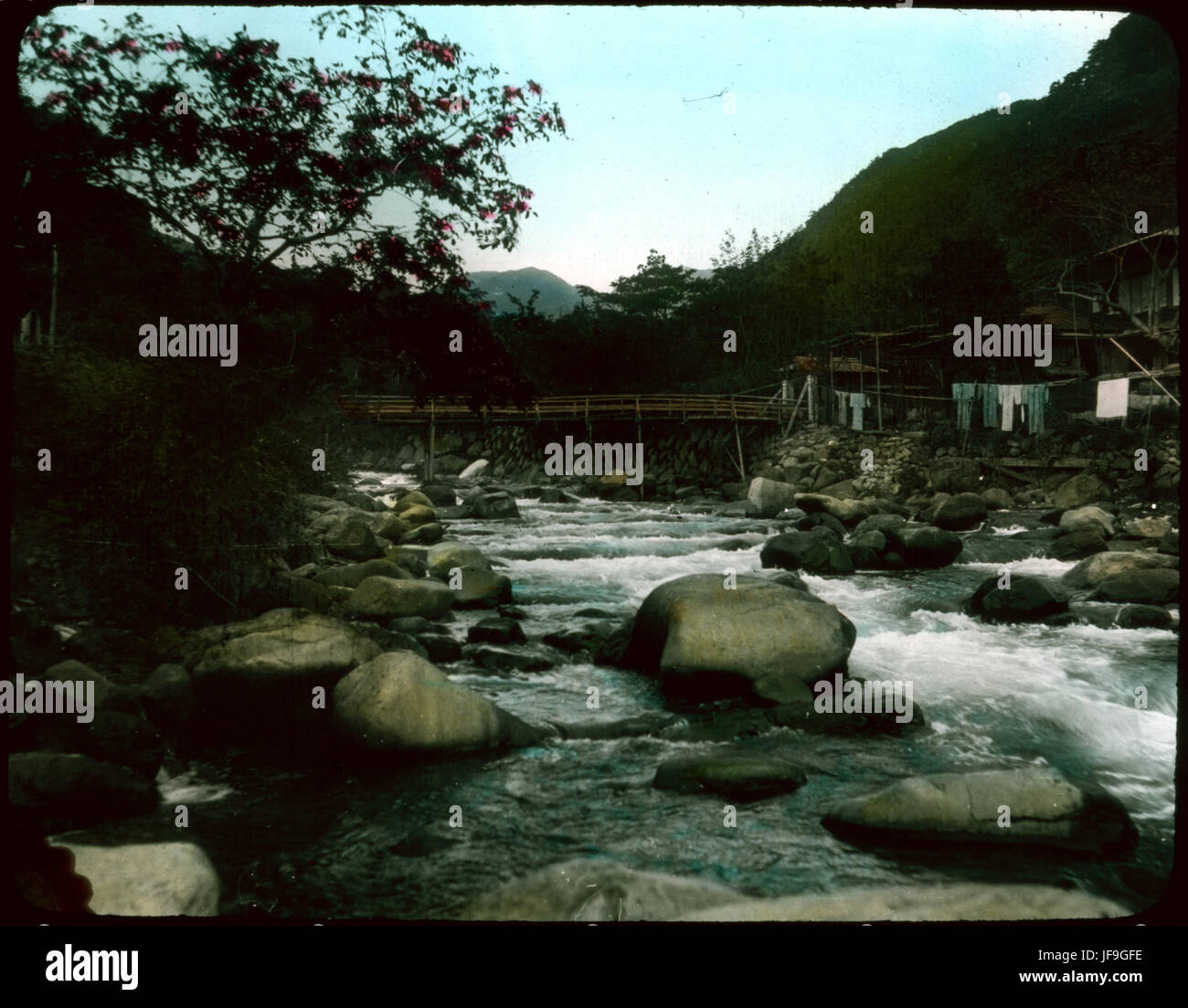 A scenic landscape showing traditional houses along a boulder-strewn ...