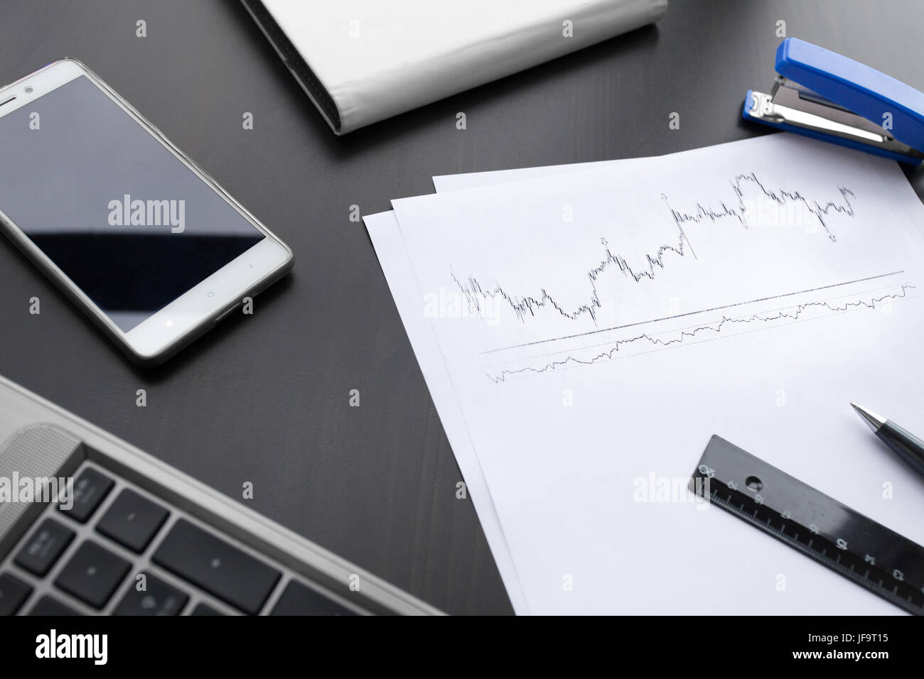 Financial graphs on office table. Studio shot Stock Photo - Alamy