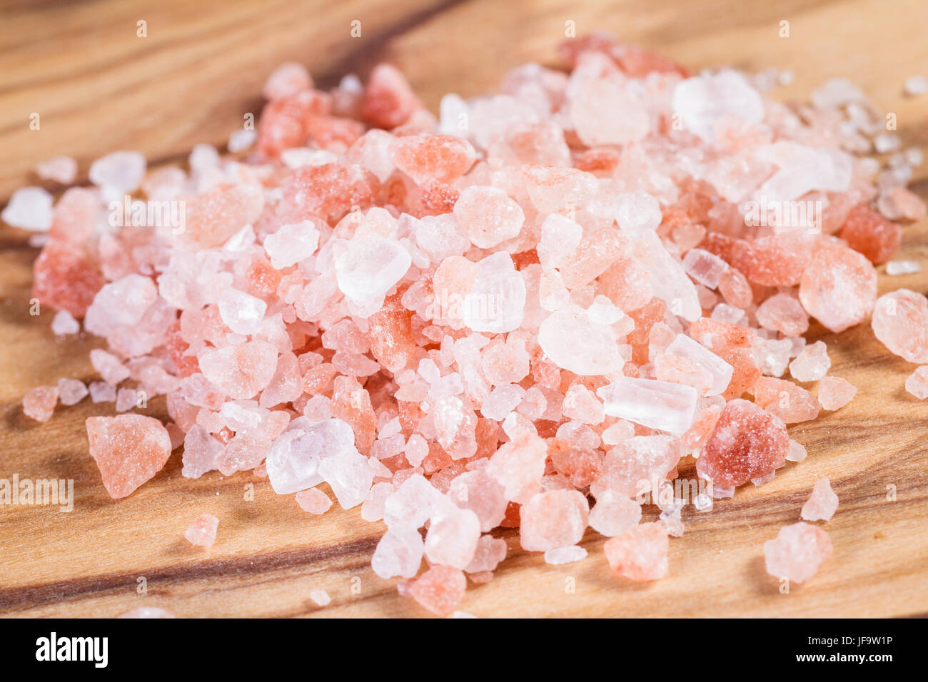 Himalayan pink salt crystals piled on a wooden cutting board Stock ...