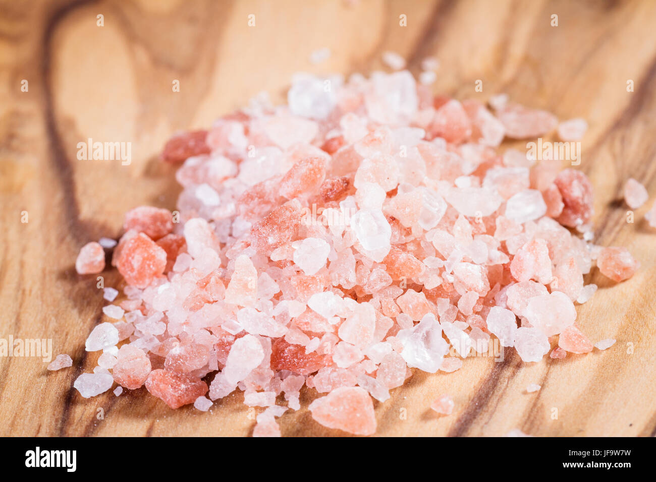 Himalayan pink salt crystals piled on a wooden cutting board Stock ...