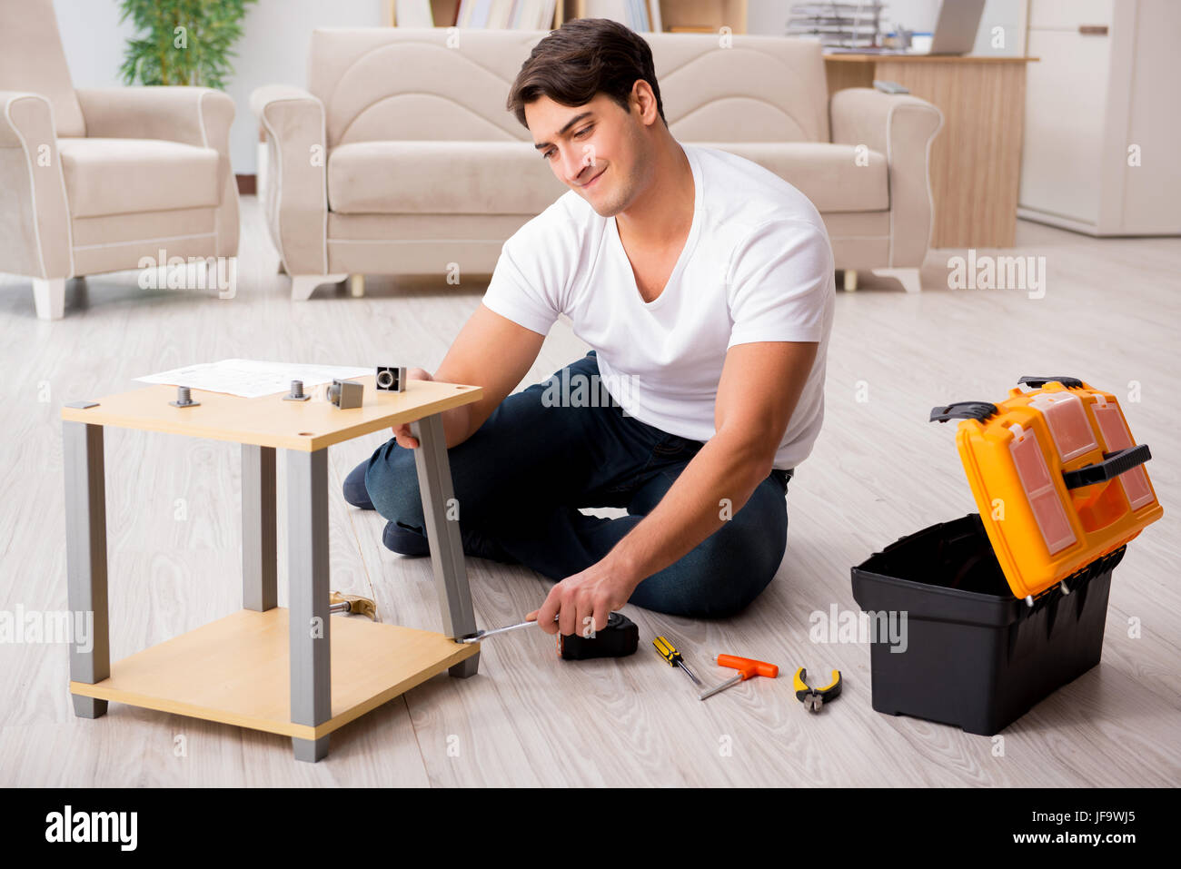 Man assembling shelf at home Stock Photo - Alamy