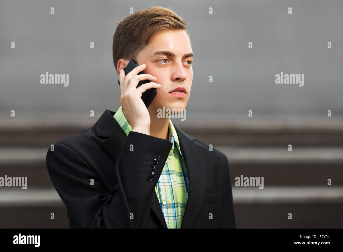 Young man calling on the mobile phone outdoor Stock Photo - Alamy