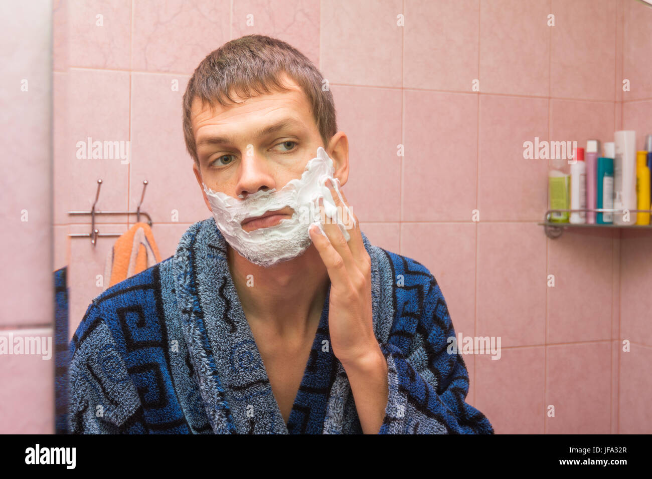 The young man gets shaving foam on face Stock Photo - Alamy