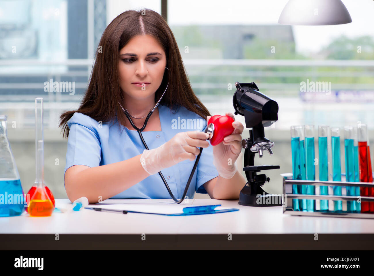 Young doctor with red heart in lab Stock Photo - Alamy