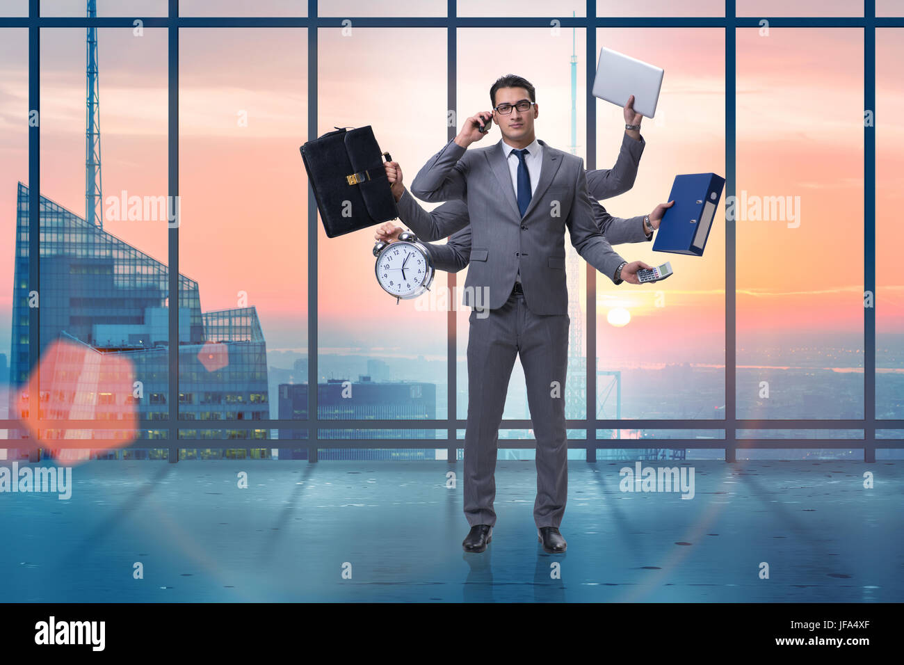 Young businessman in multitasking concept Stock Photo - Alamy