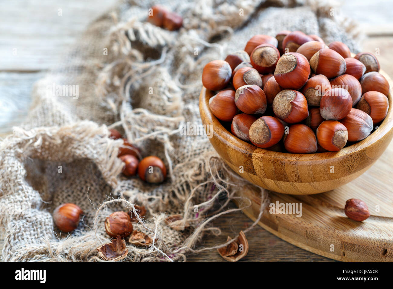 Wooden bowl with hazelnuts and old sacking Stock Photo - Alamy