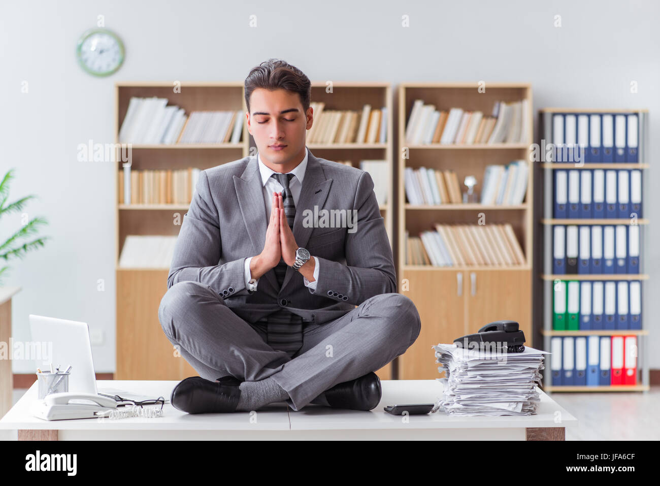 Business man meditating on desk hi-res stock photography and images - Alamy