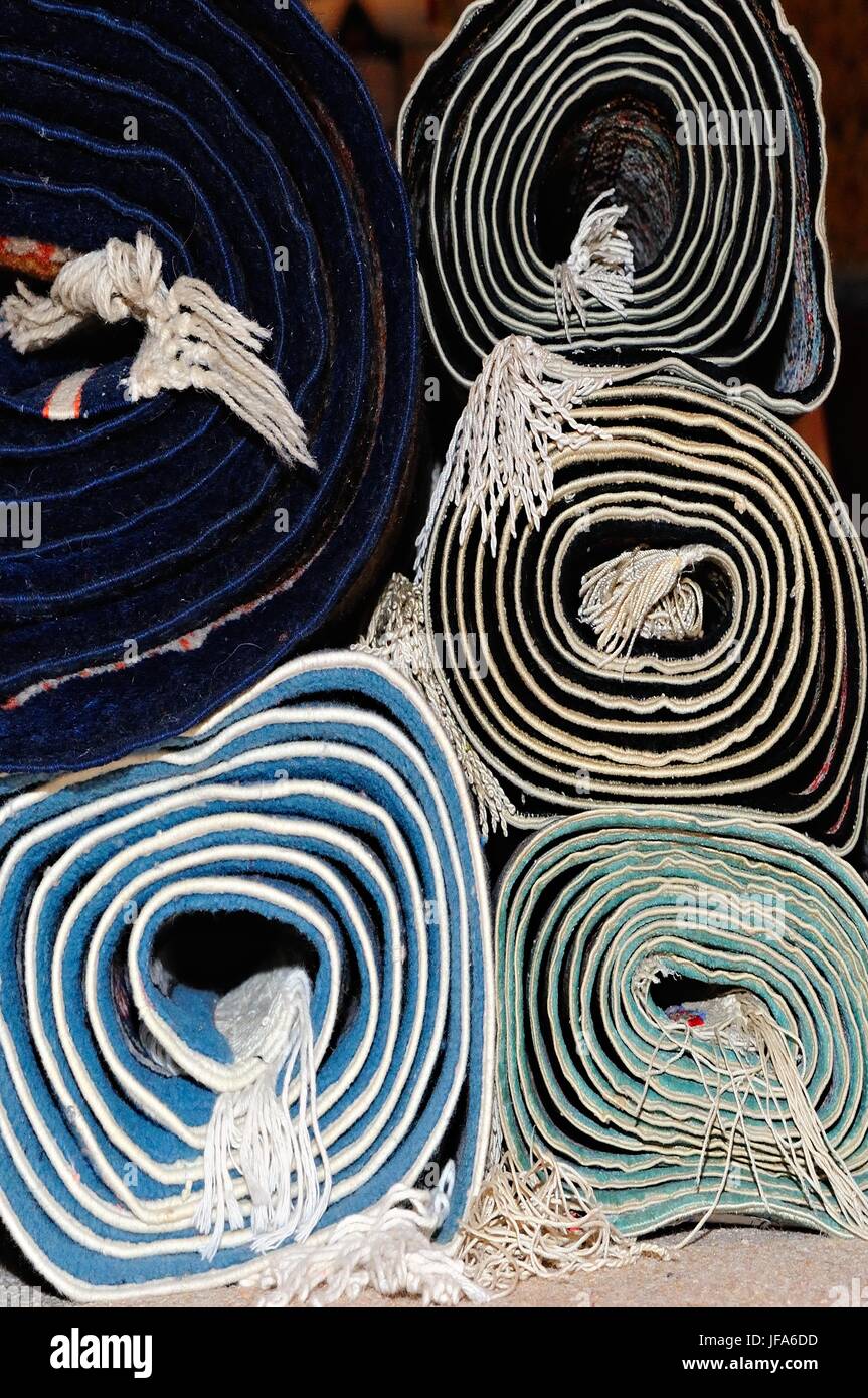 Rolled on each other floor carpets Stock Photo - Alamy