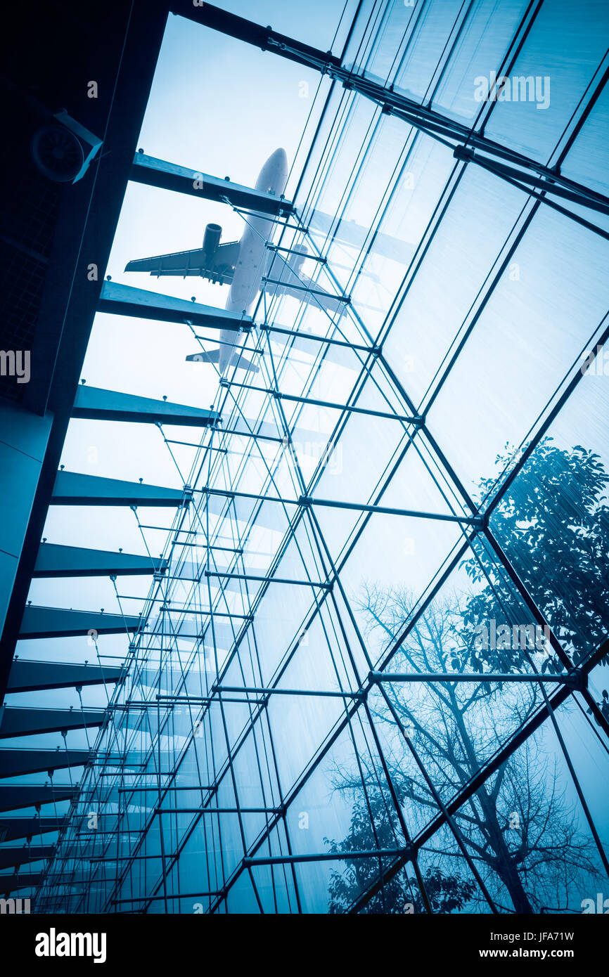 airplane above the glass building Stock Photo - Alamy