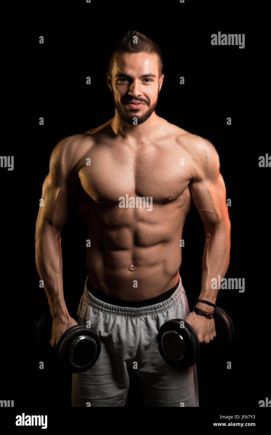 Muscular Model Doing Heavy Weight Exercise For Biceps With Dumbbells On ...